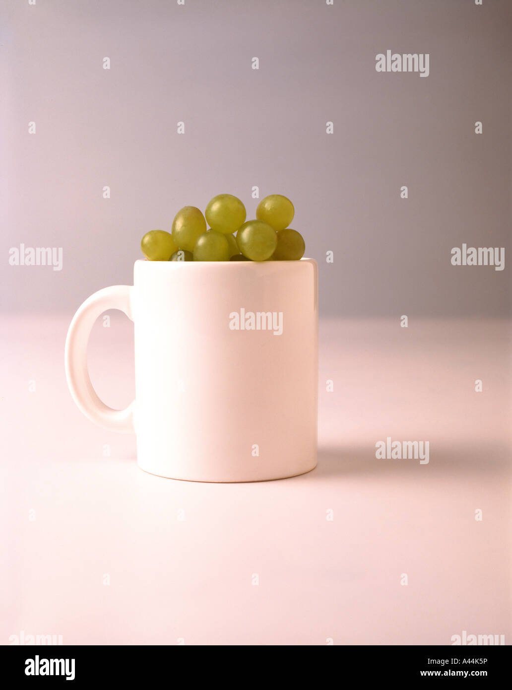 Green grapes and white coffee or tea cup mug Stock Photo - Alamy
