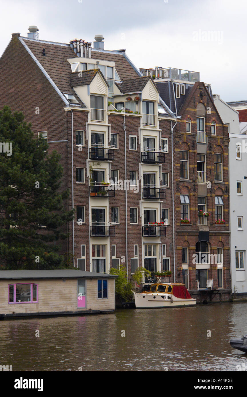 Modern canal house built adjacent to a traditional one, with a floating ...