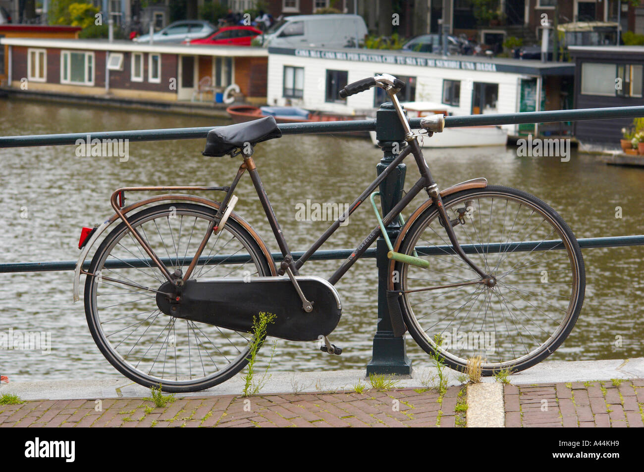 Traditional-style bicycle locked to the railing of a bridge crossing ...