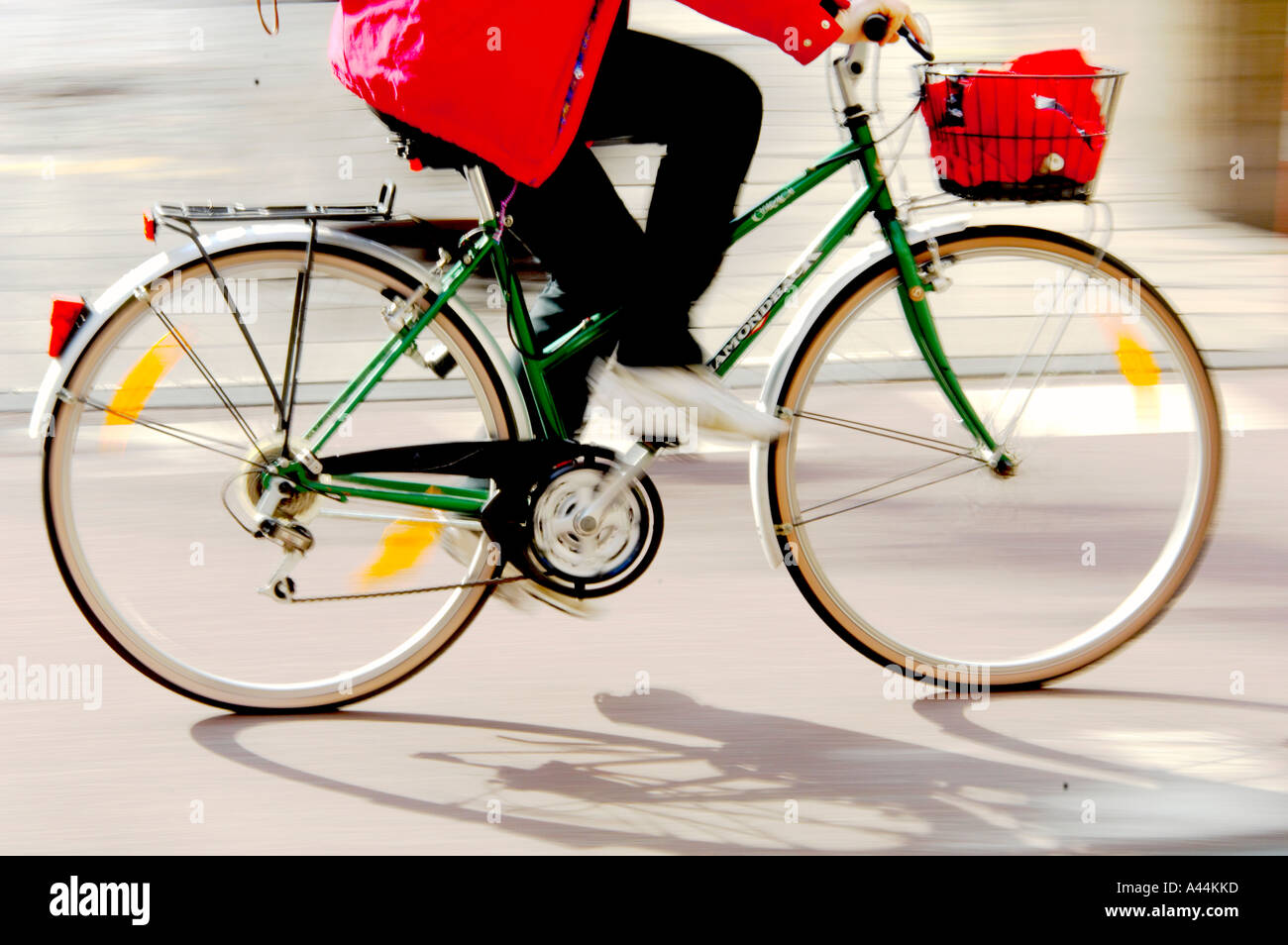 Blurred side view of a moving bicycle, focusing on the rider’s legs ...