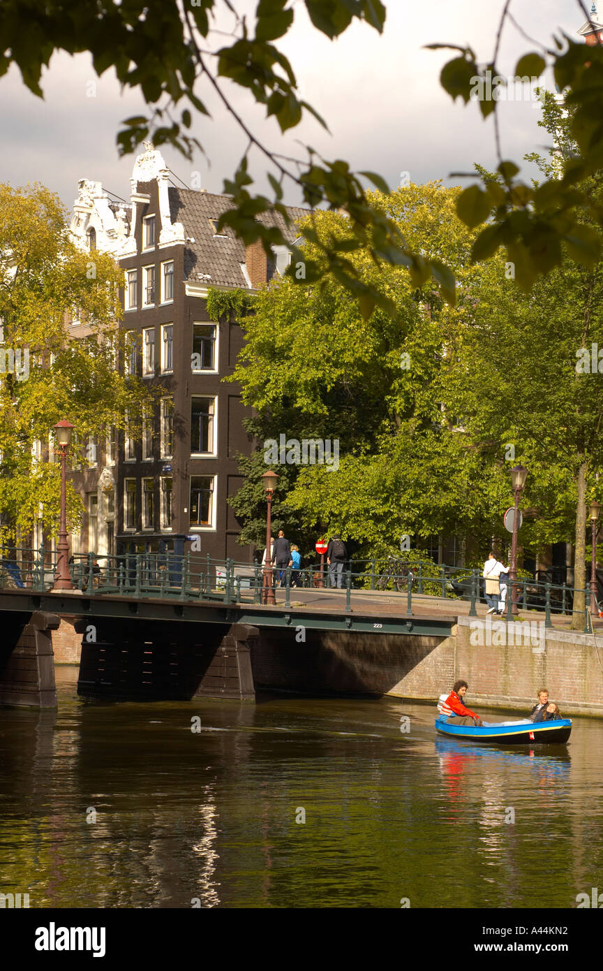 Bridge crossing a canal in Amsterdam with narrow canalside houses in ...
