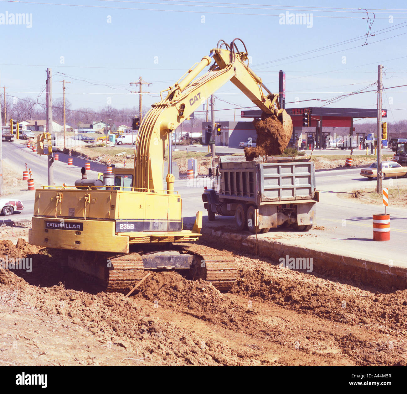 track excavator loading extra fill dirt into a dump truck Stock Photo ...