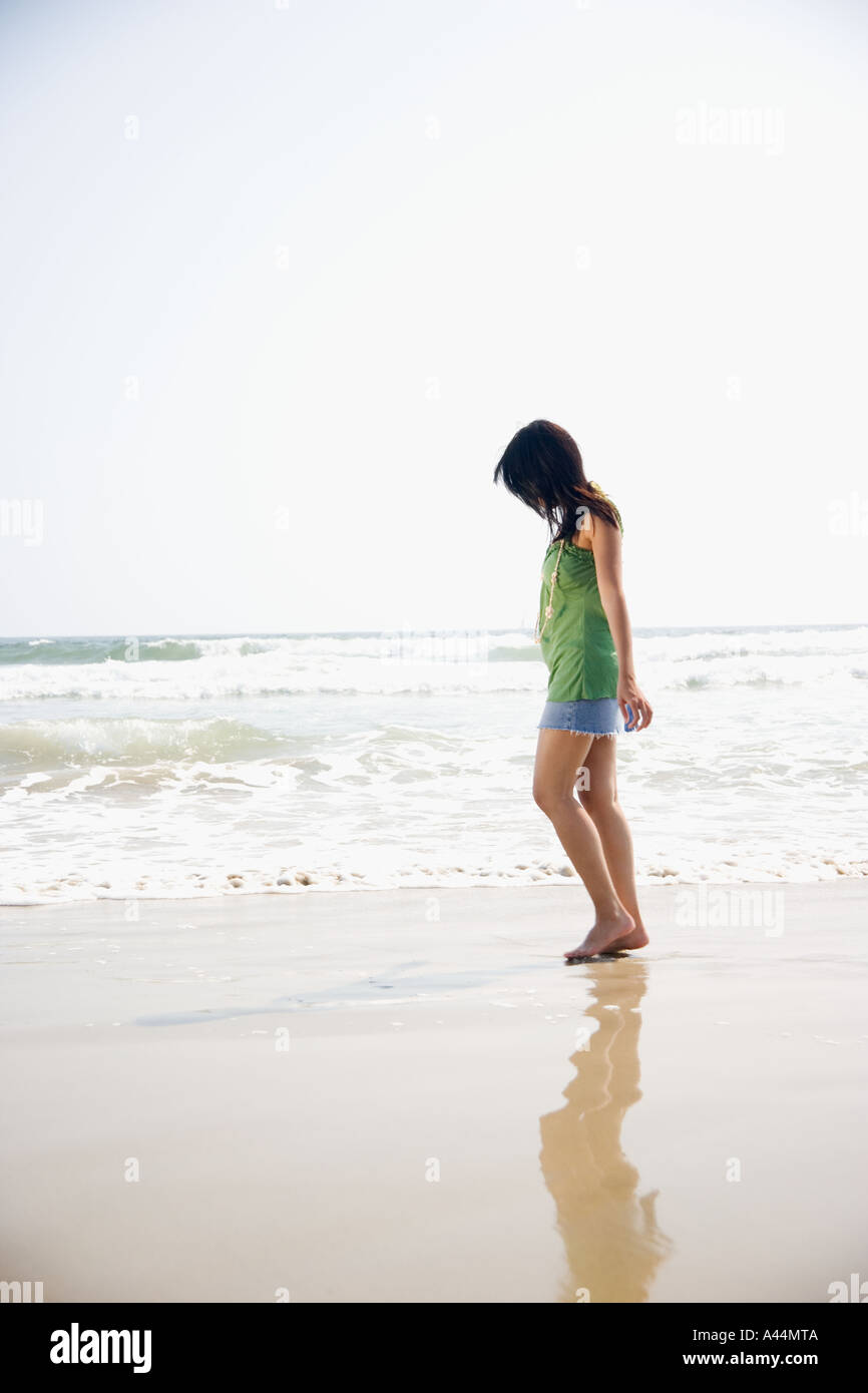 Side view of woman walking on beach Stock Photo - Alamy