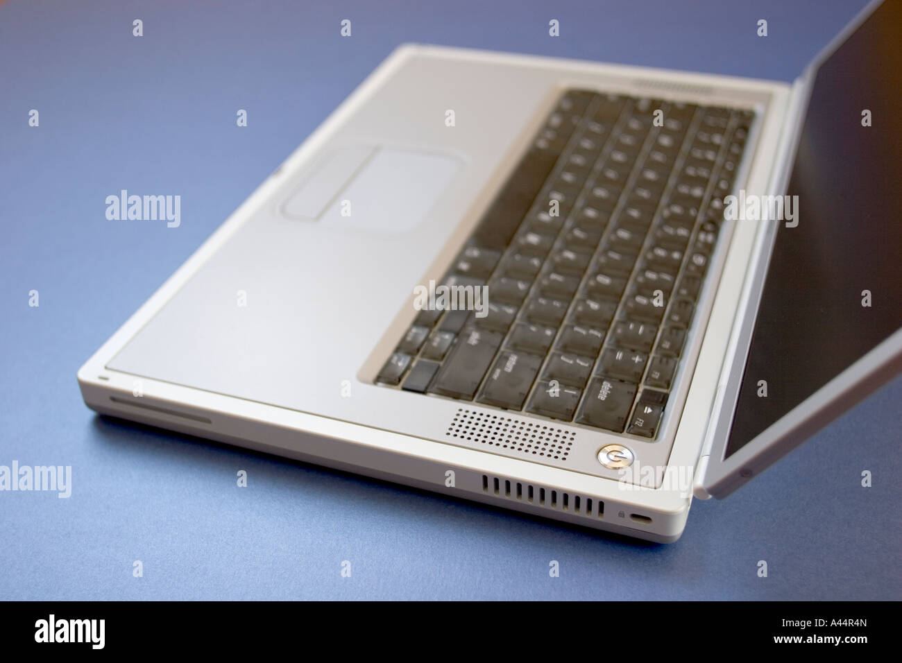 Silver laptop computer on blue background Stock Photo - Alamy