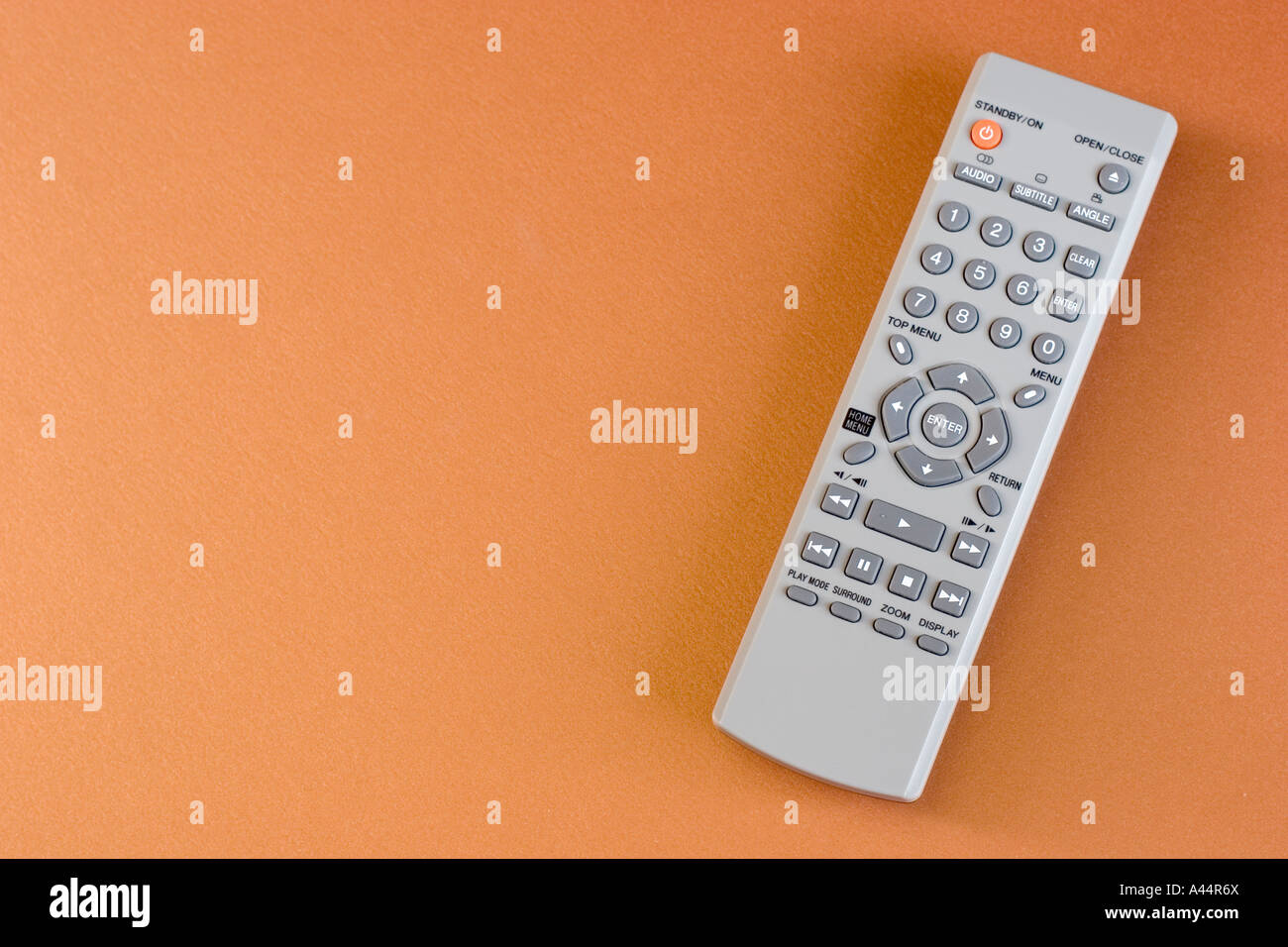 TV DVD stereo audio or home entertainment remote control on an orange ...