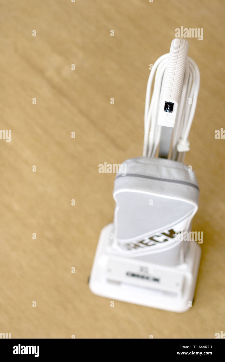 Household vacuum cleaner on a simple abstract gold or yellow background ...