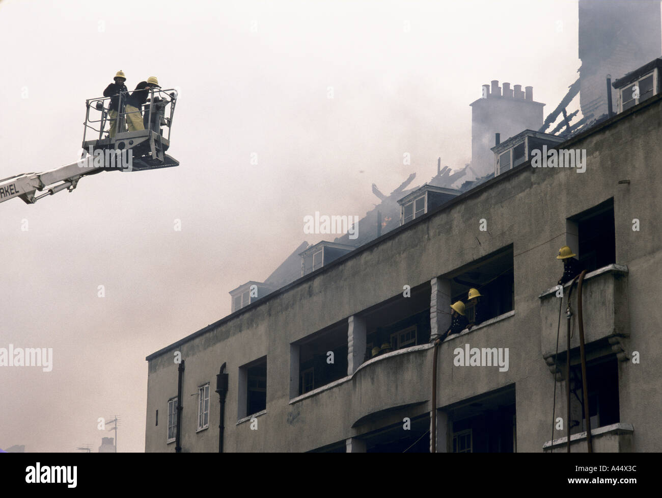 firemen in action using elevated hydraulic platform at fire in flats ...
