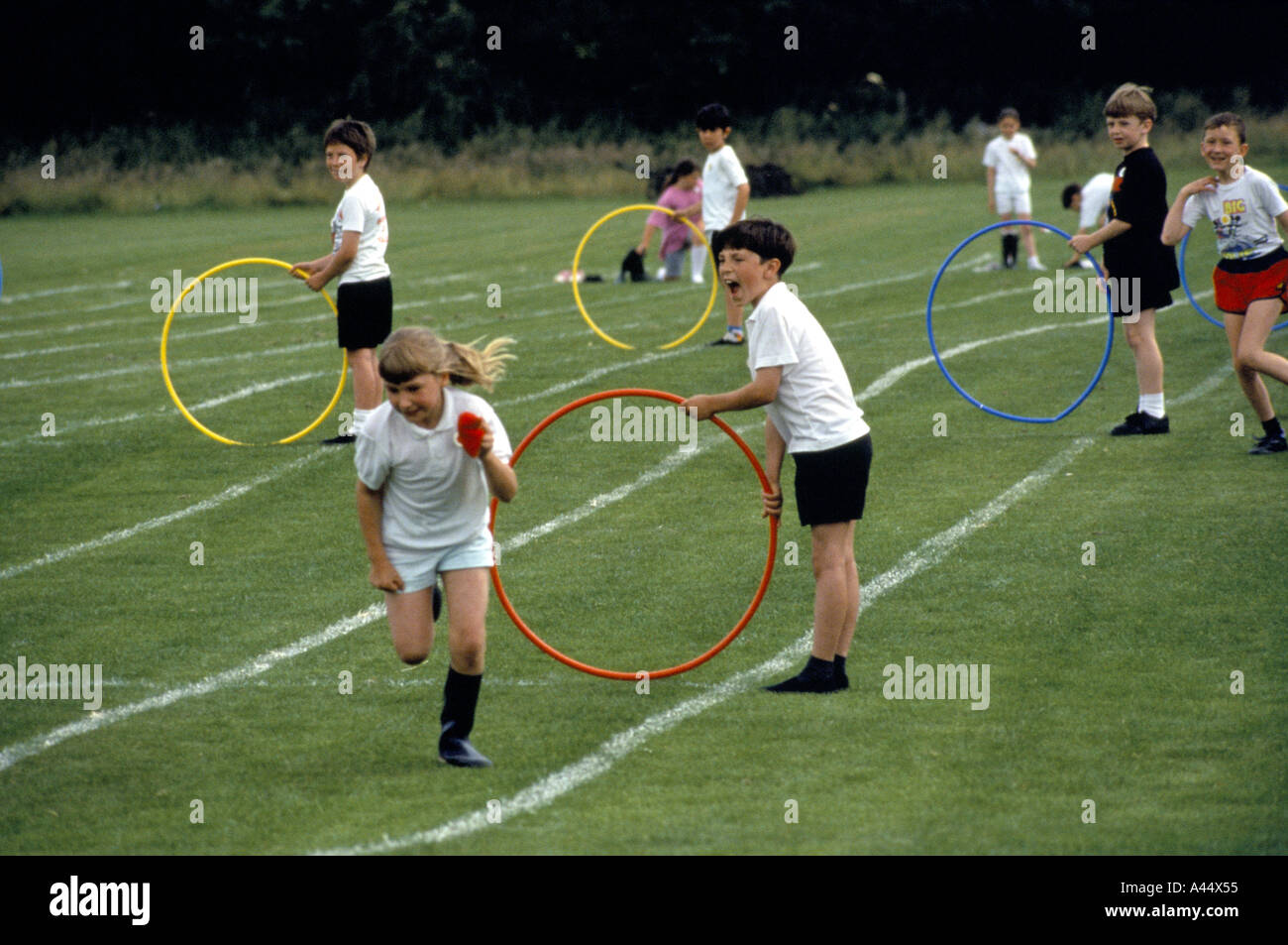 children with hoops on the tracks on a primary school sports day in ...