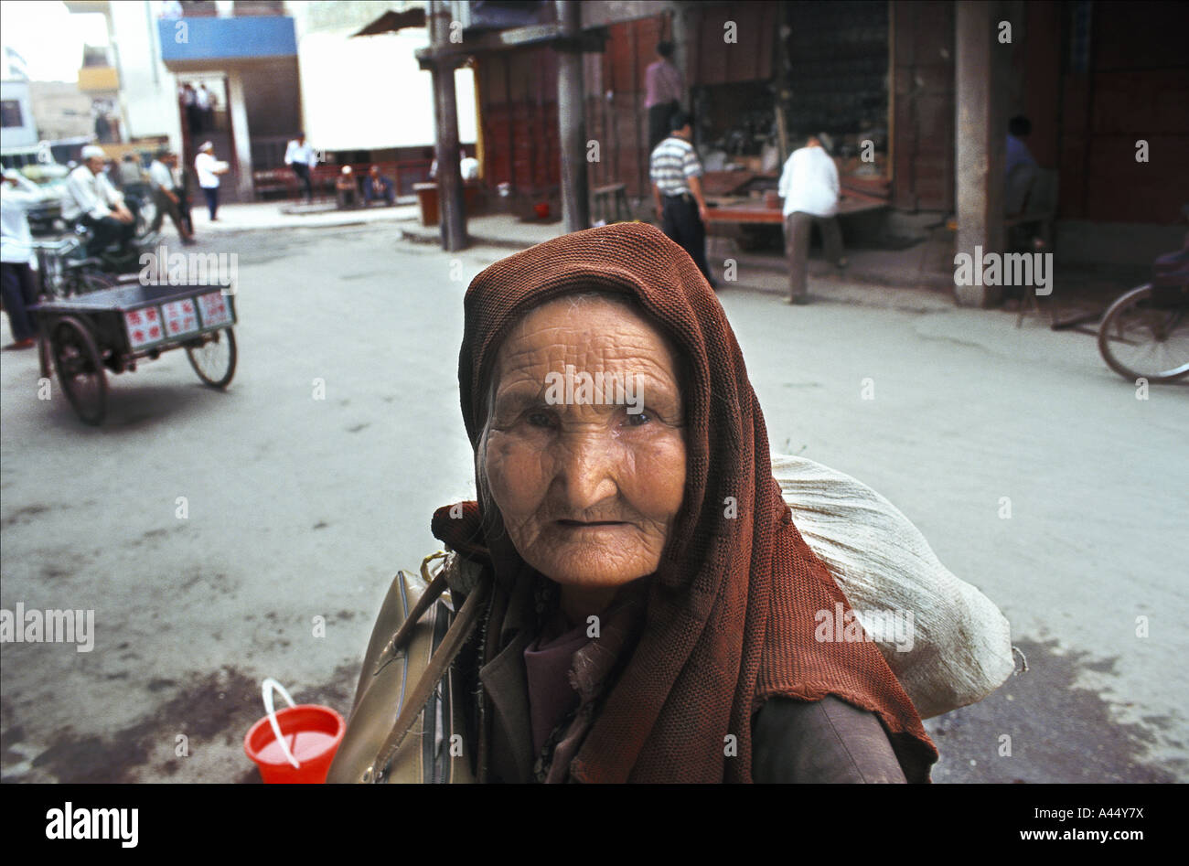 An old lady checks the photographer in front of her. Kashgar, Xinjiang ...