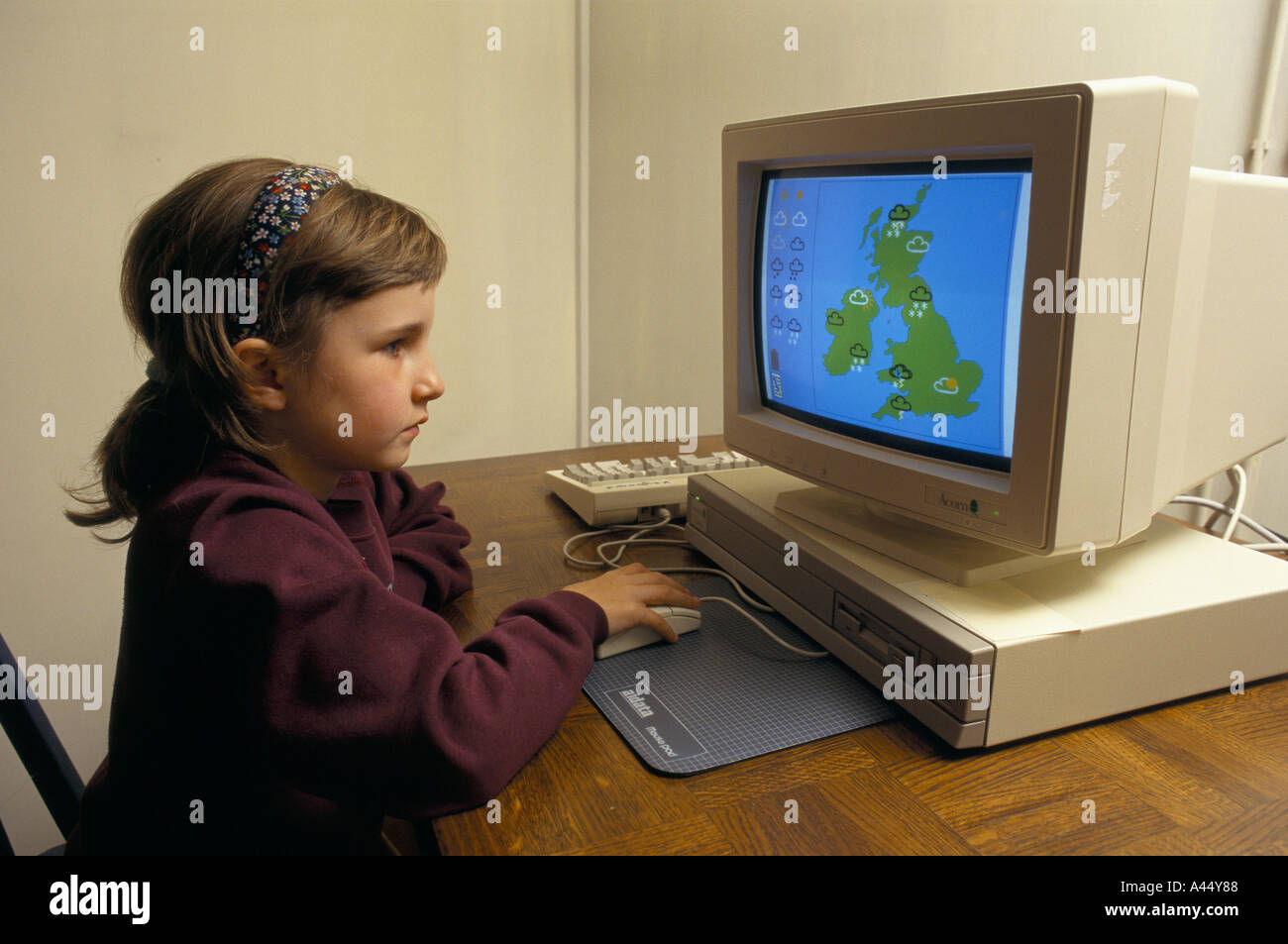 seven year old girl with computer using my world weather programme ...