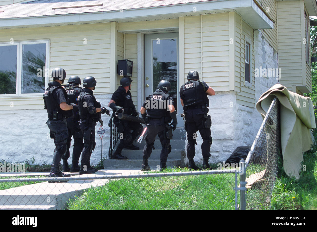 Police SWAT TAC Team entering suspects residence to serve search Stock ...