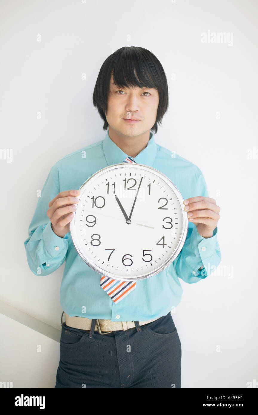 Businessman holding a clock Stock Photo - Alamy