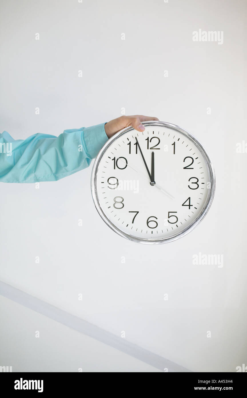Hand holding a clock Stock Photo - Alamy