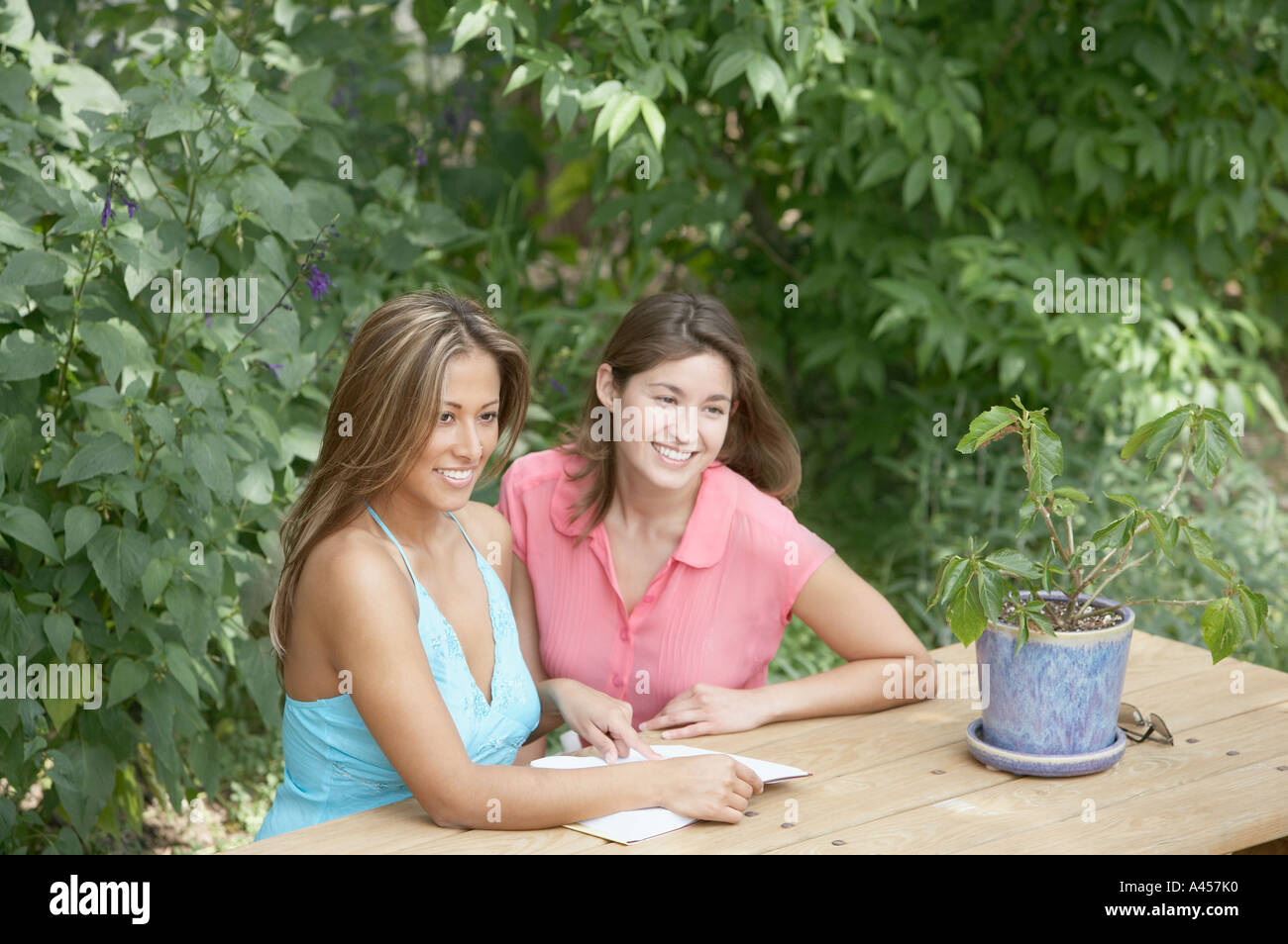 Two women sitting at picnic table Stock Photo - Alamy