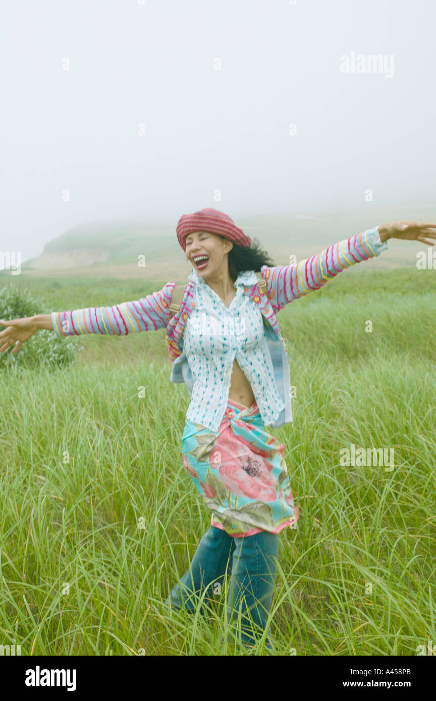 Woman laughing with arms outstretched in field Cape Cod Massachusetts ...