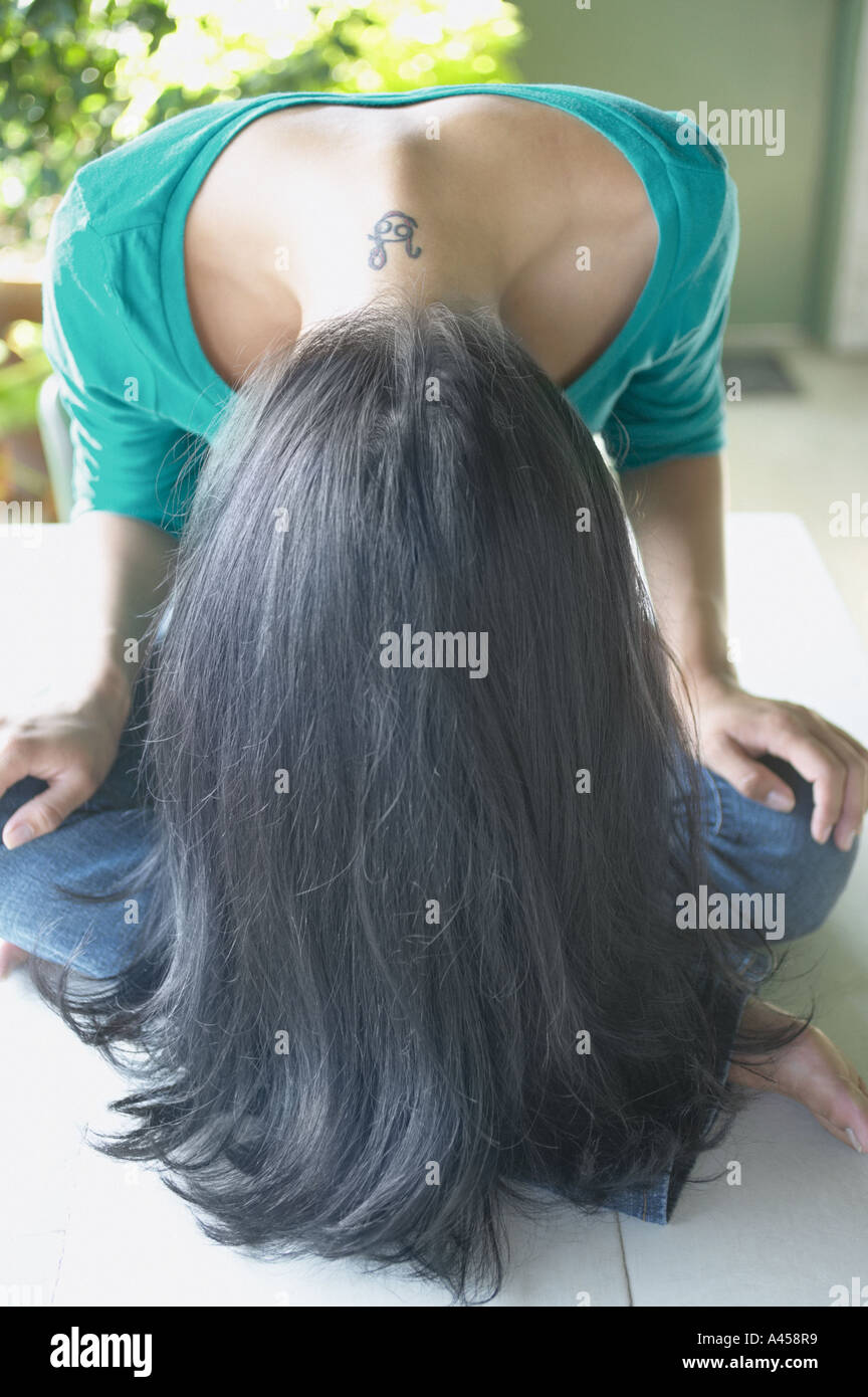 Woman with head bent forward and tattoo on back of neck Stock Photo - Alamy