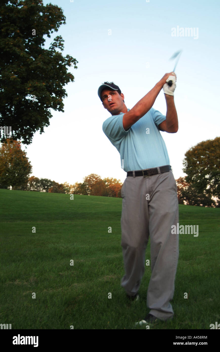 male golfer following through with shot Stock Photo - Alamy