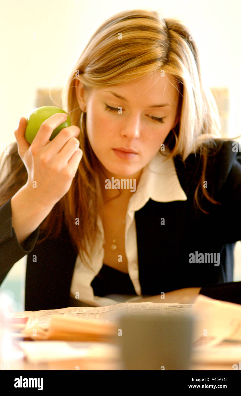 Office worker eating a healthy lunch. Young pretty woman enjoying an ...