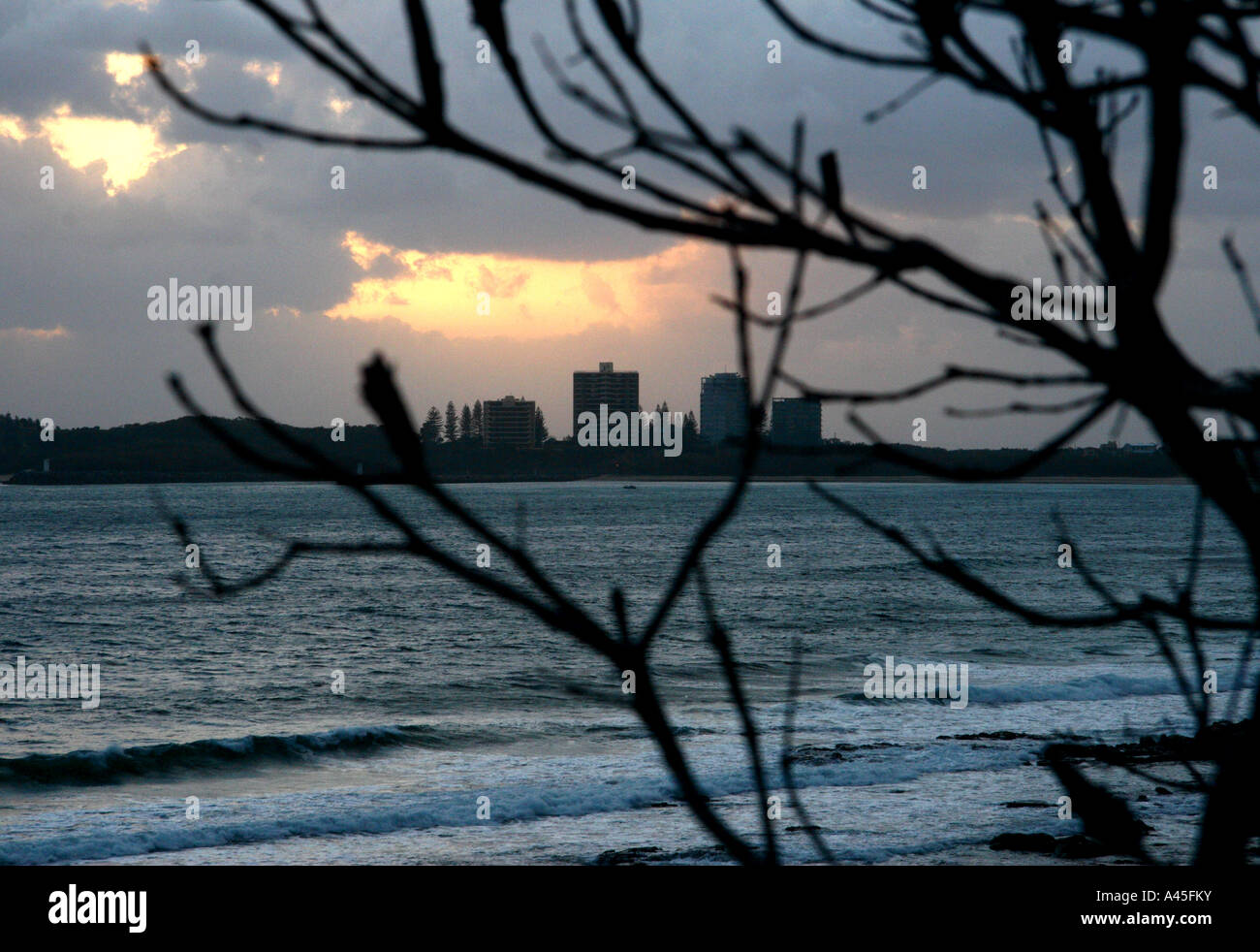 sunrise on lighthouse on beach clouds gods light rocks Stock Photo - Alamy
