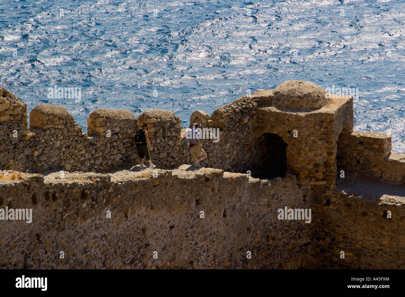 Hikers on ancient sea wall surrounding the town of Monemvasia Greece ...