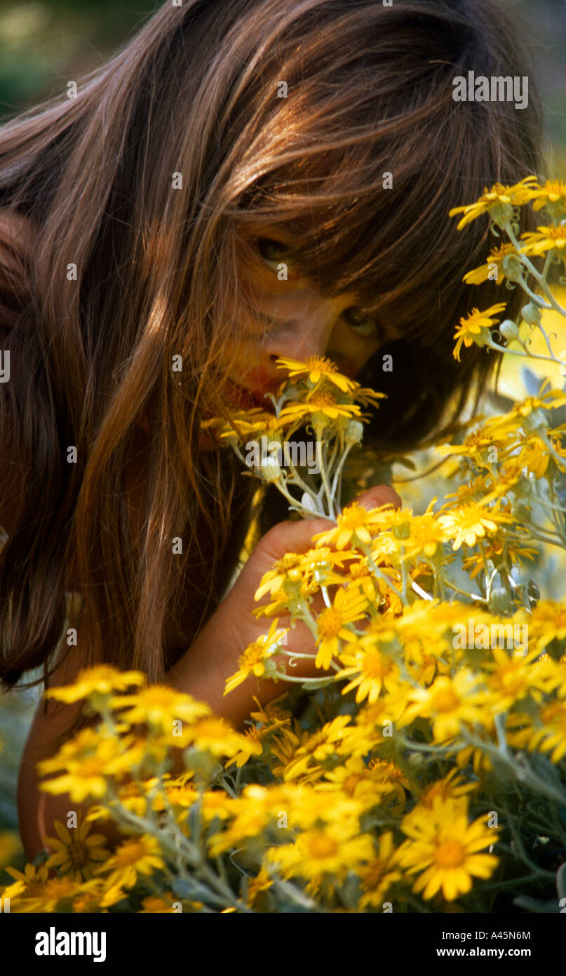 Girl Smelling A Flower Stock Photo - Alamy