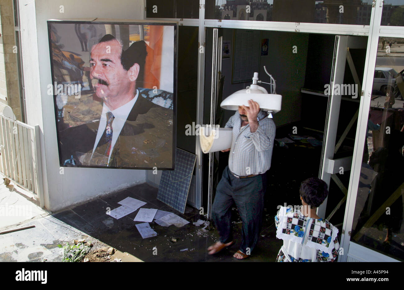 a man takes a washbasin from a government building as extensive looting ...