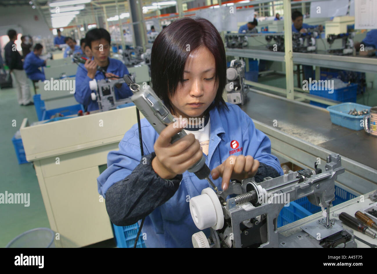 workers on the assembly line at the feiyue group sewing machine factory ...