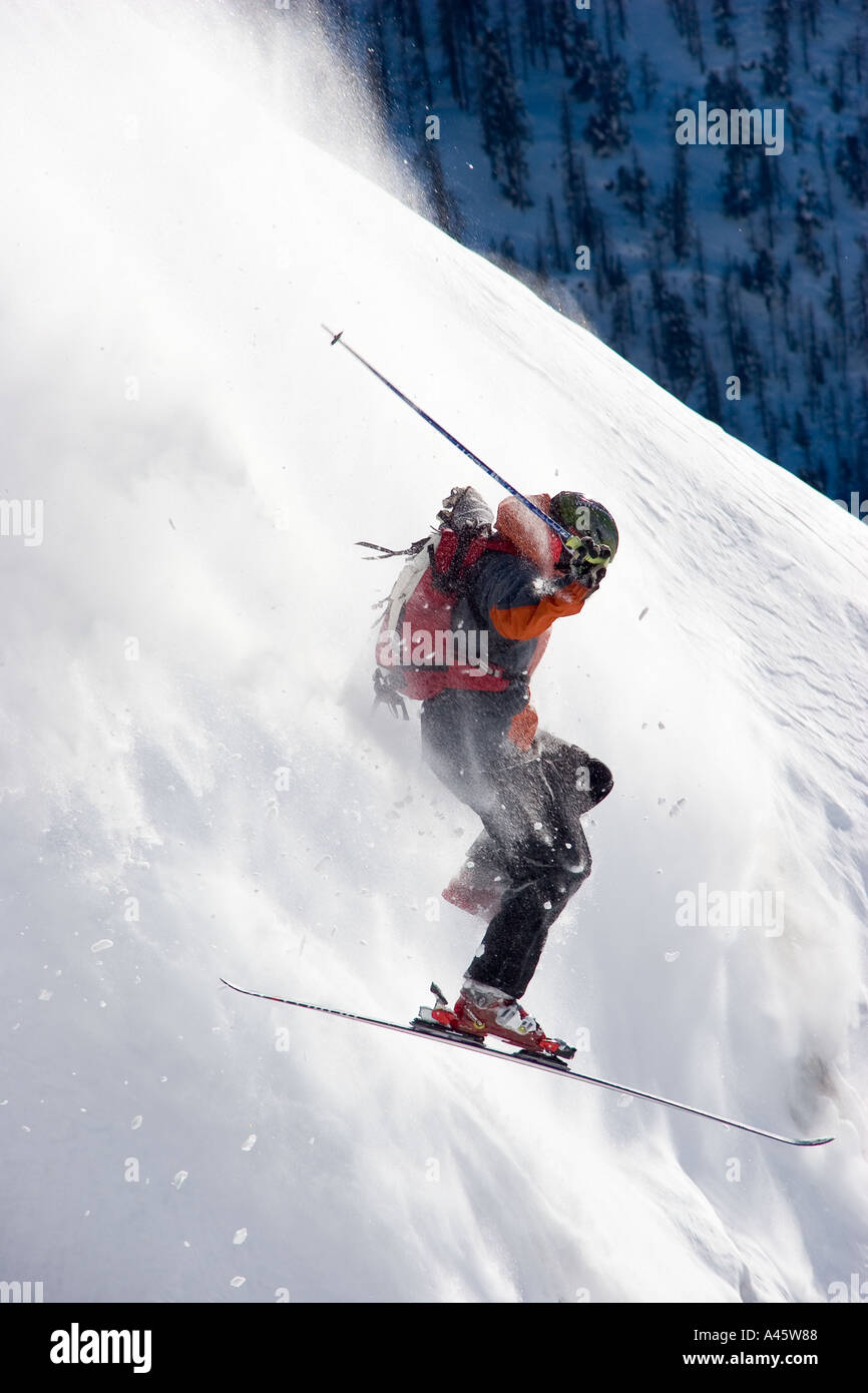 Man skiing at speed with snow falling all around and has lost one ski ...