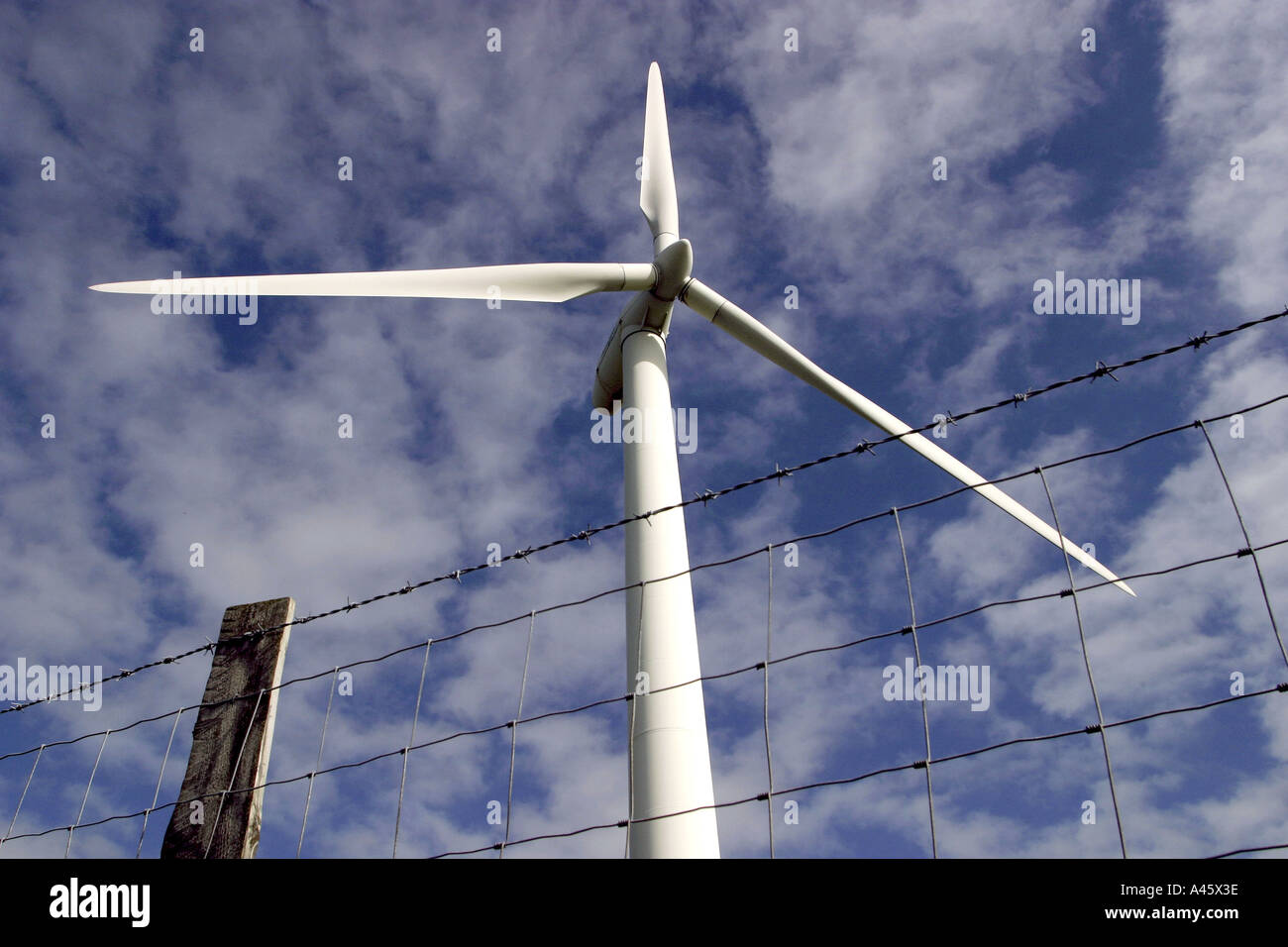wire netting in front of a windmill electricity turbine on the mynydd ...