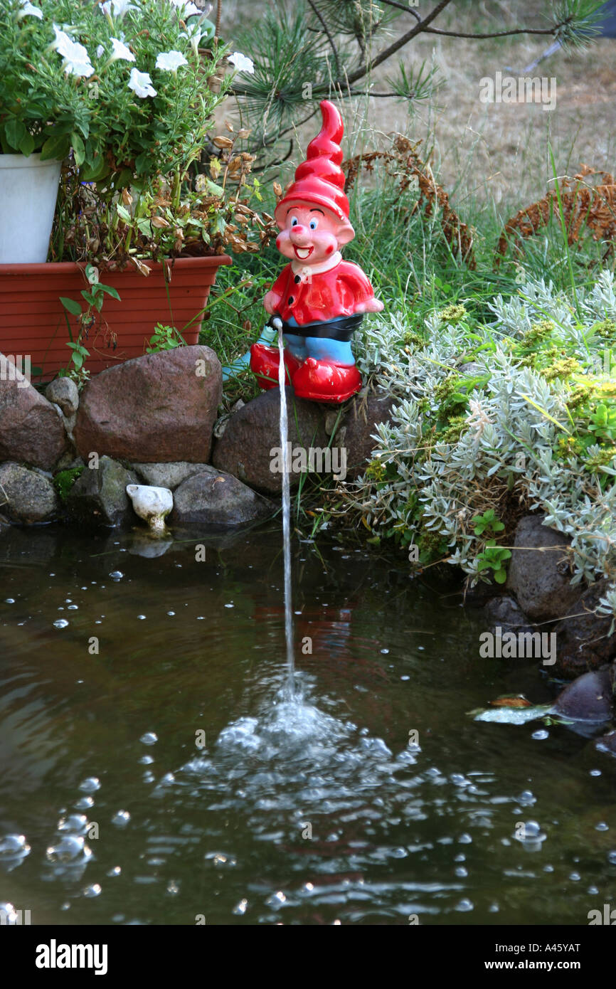 Funny dwarf puring water into the small garden pond Stock Photo - Alamy