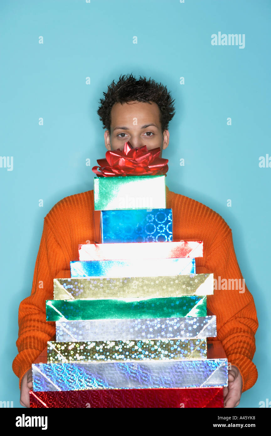 Young man behind stack of gifts Stock Photo - Alamy