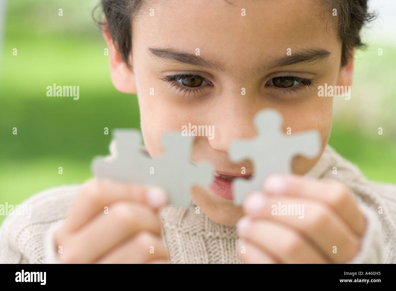 Boy fitting puzzle pieces together Stock Photo - Alamy