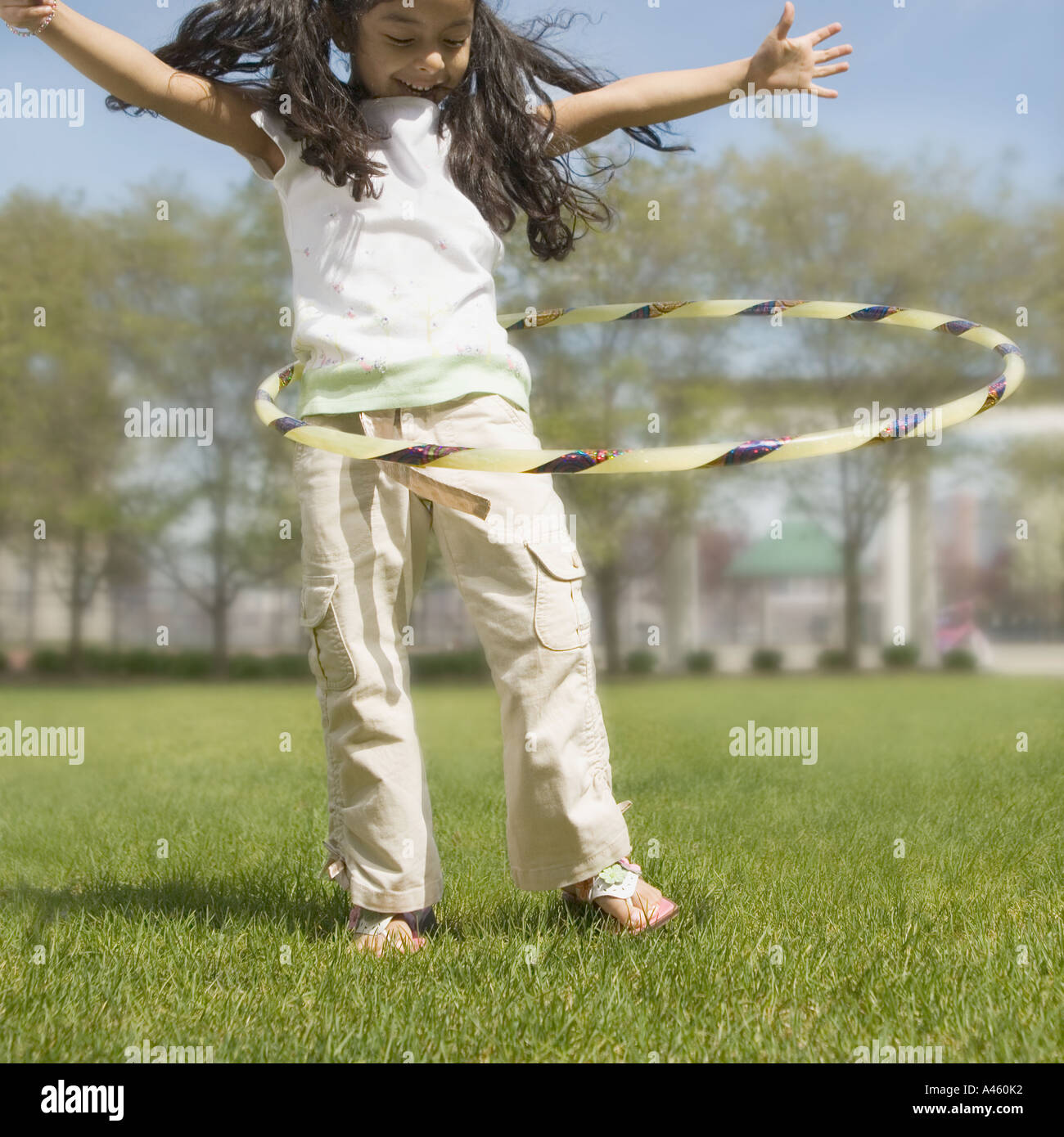 Young girl rotating a hula hoop Stock Photo - Alamy