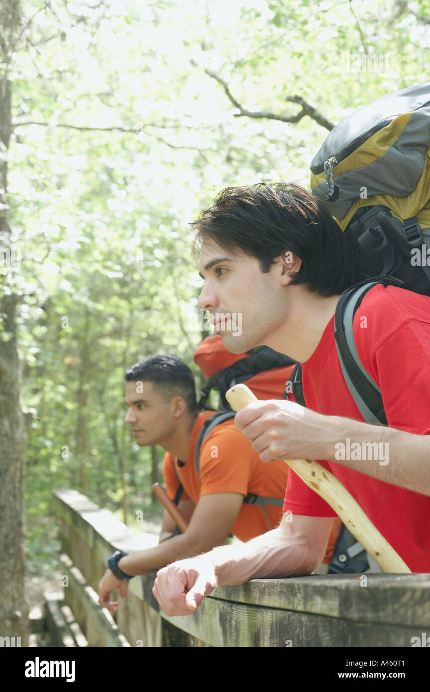 Two young men leaning on a forest railing Stock Photo - Alamy