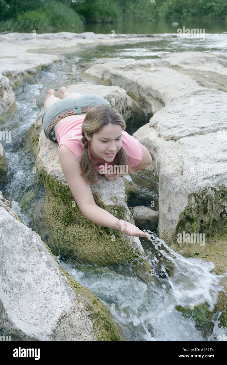 Young woman splashing water in a stream Stock Photo - Alamy
