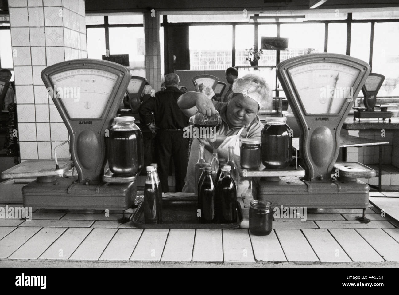 Russian market trader measuring cooking oil in St Petersburg No 37 ...