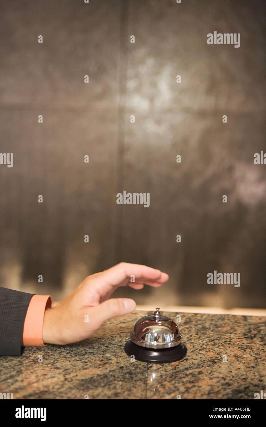Hand reaching for service bell on counter Stock Photo - Alamy
