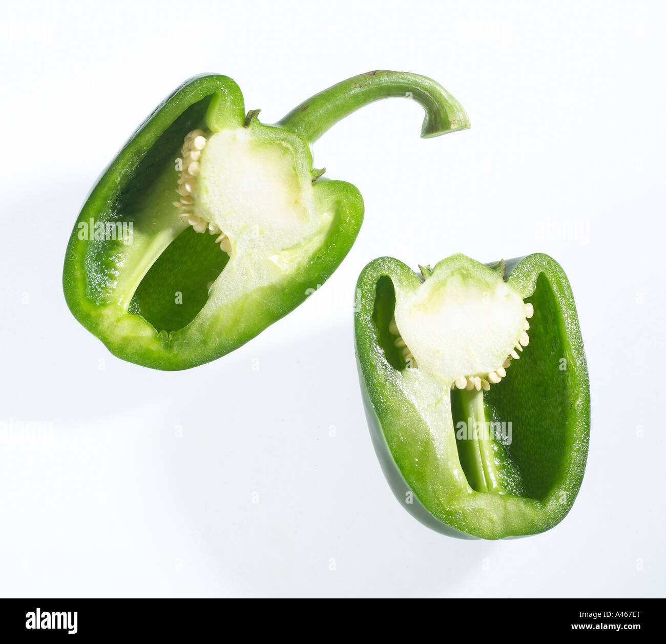 A green bell pepper cut in half on a white background Stock Photo - Alamy