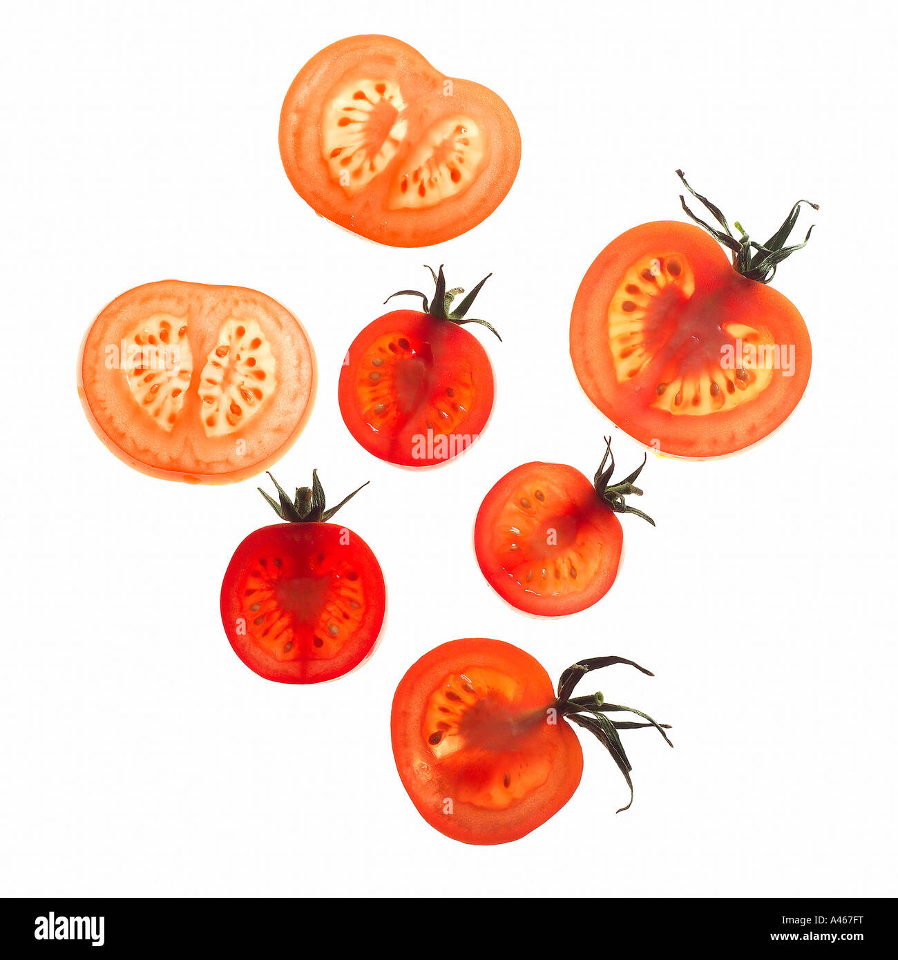 Tomatoes cut in halves and slices on a white background Stock Photo - Alamy