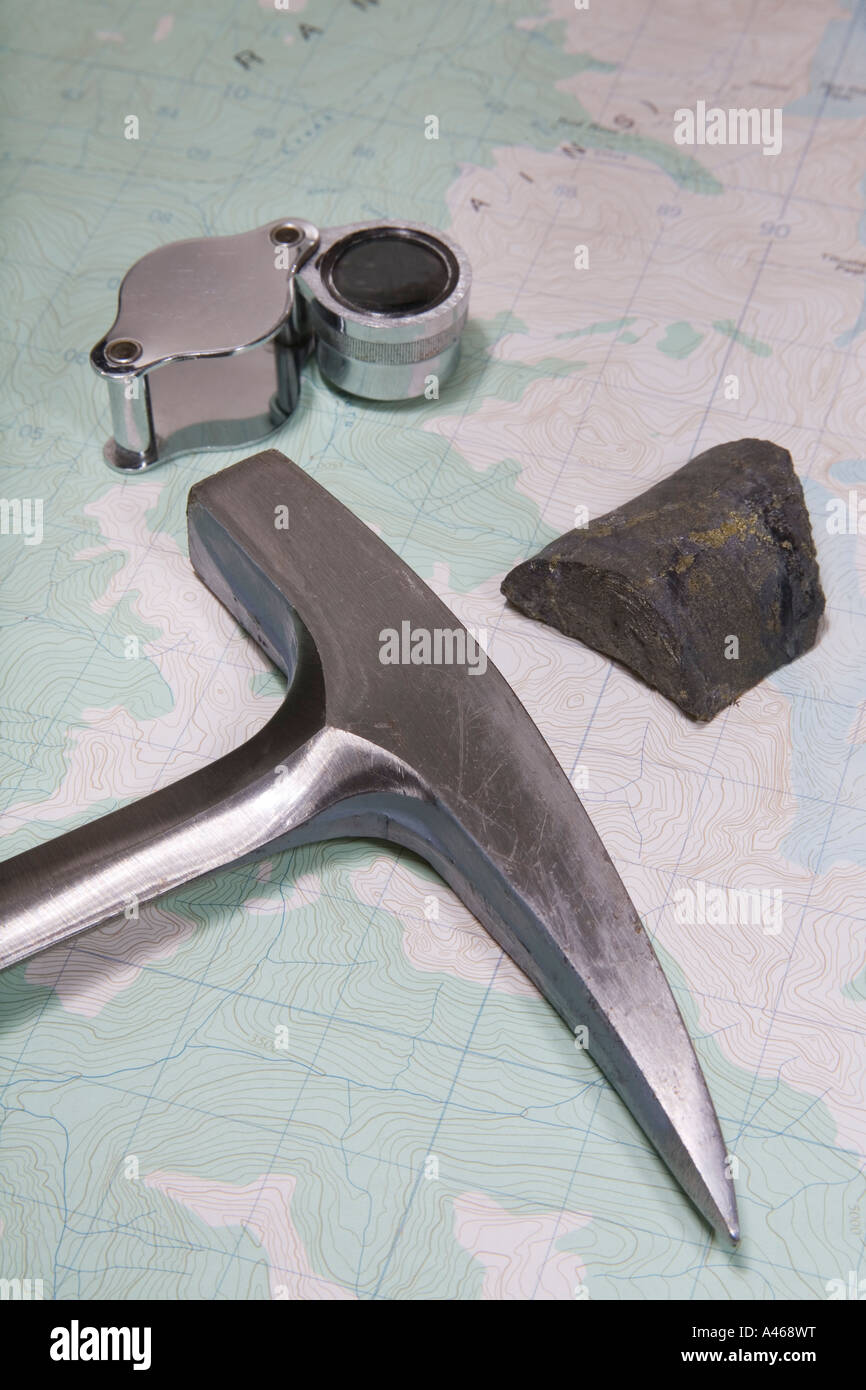 Mineral concept with geologist rock hammer magnifier mineral on contour ...