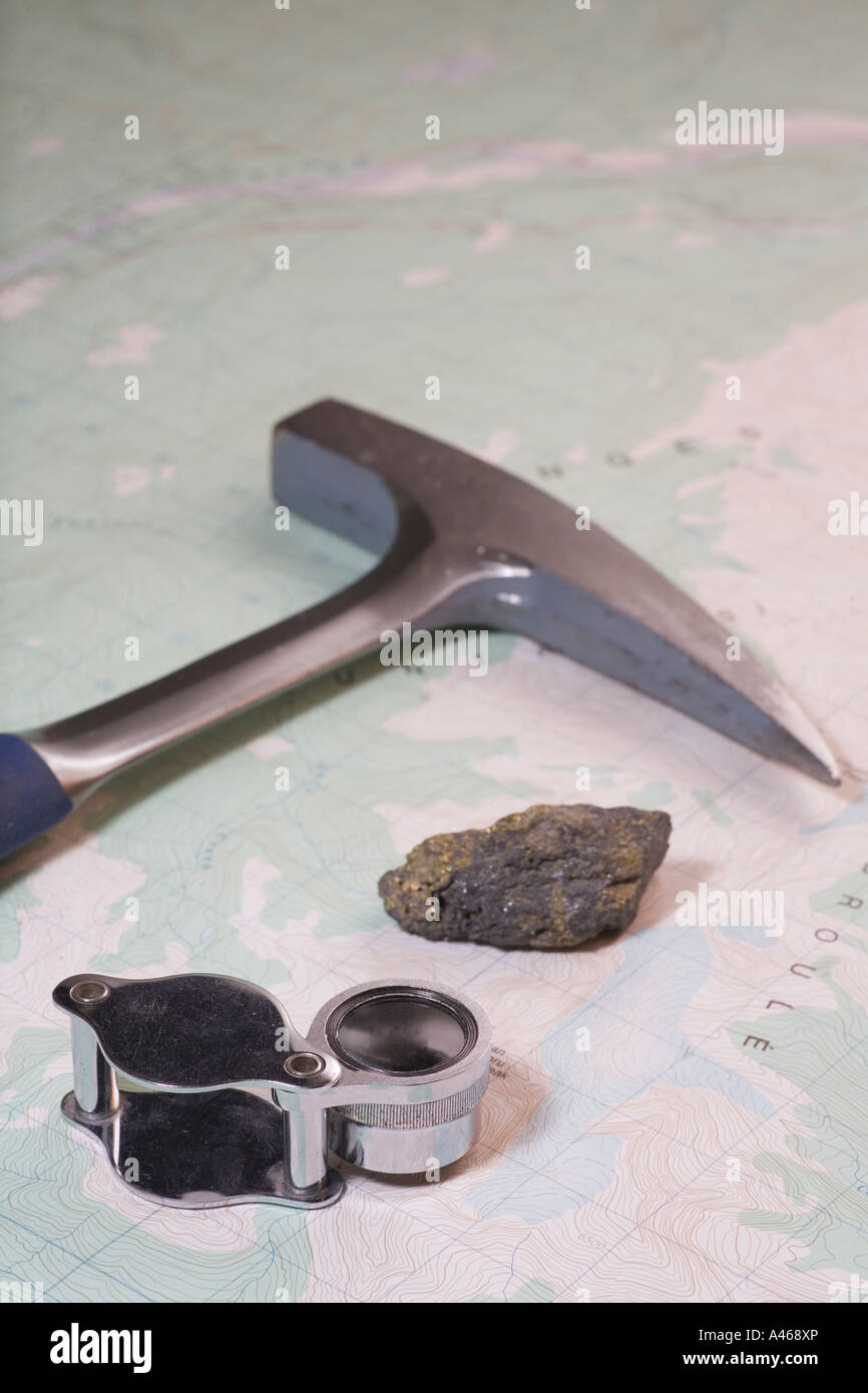 Mineral exploration concept with geologists rock hammer magnifier ...