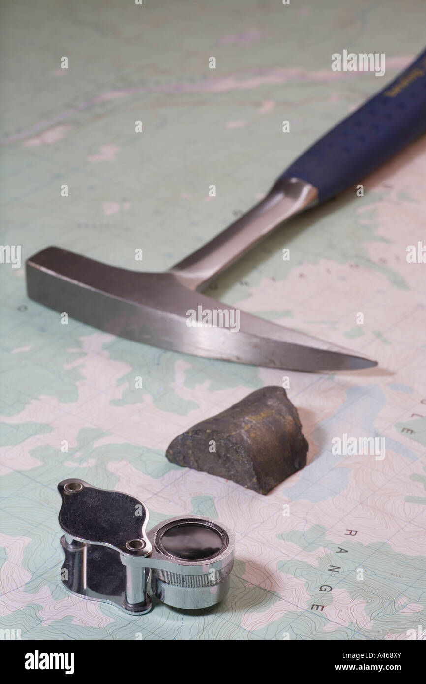 Mining concept with geologists rock hammer magnifier mineral on contour ...