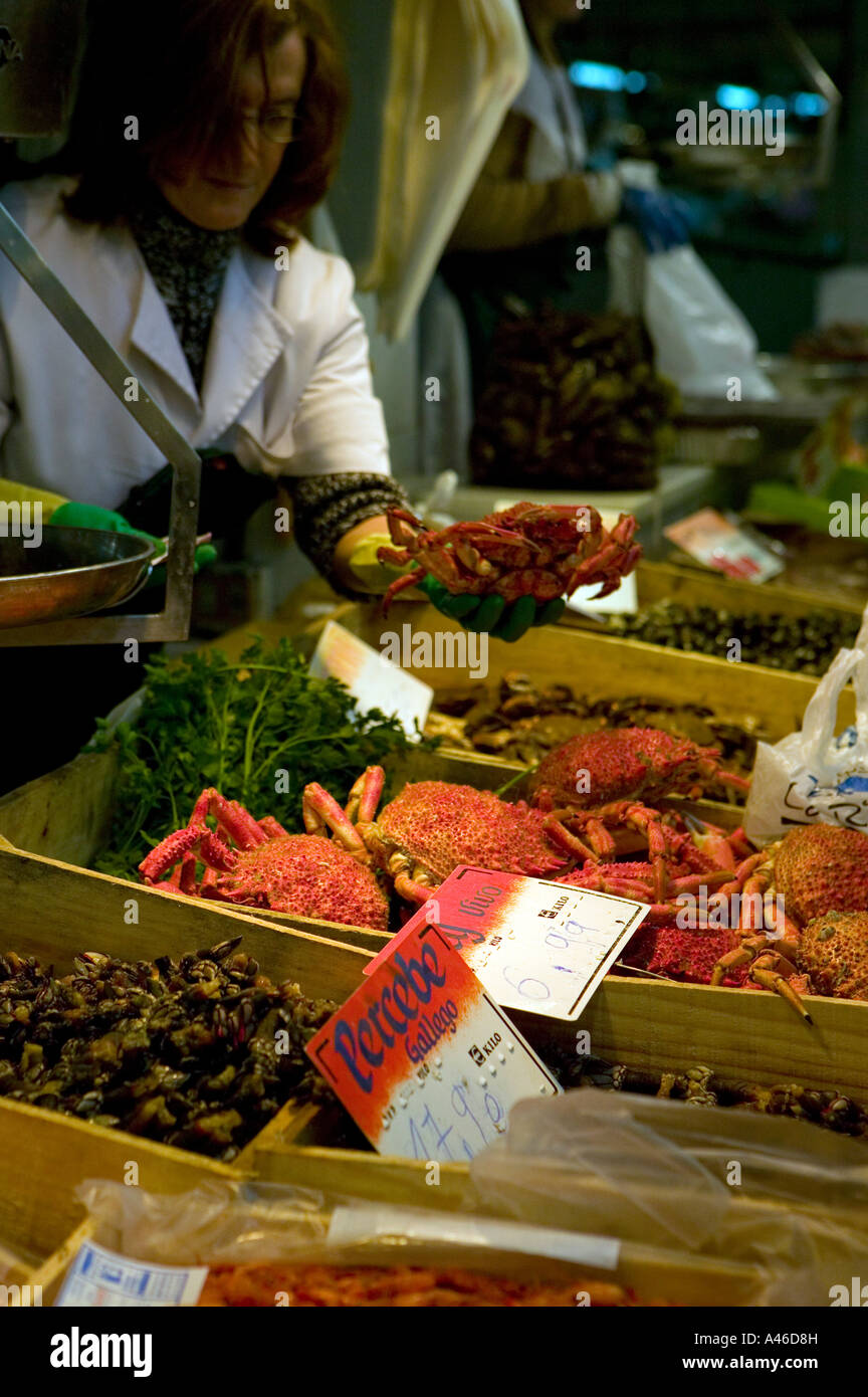 Female fishmonger holding a fresh crab on sale in Mercado de la Rivera ...