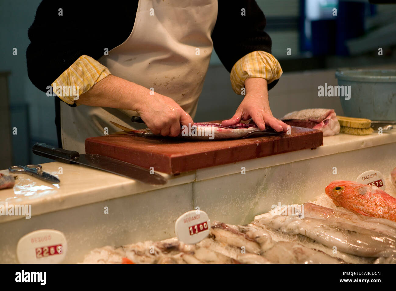Fishmonger filleting fresh fish in Mercado de la Rivera, Bilbao, Pais ...