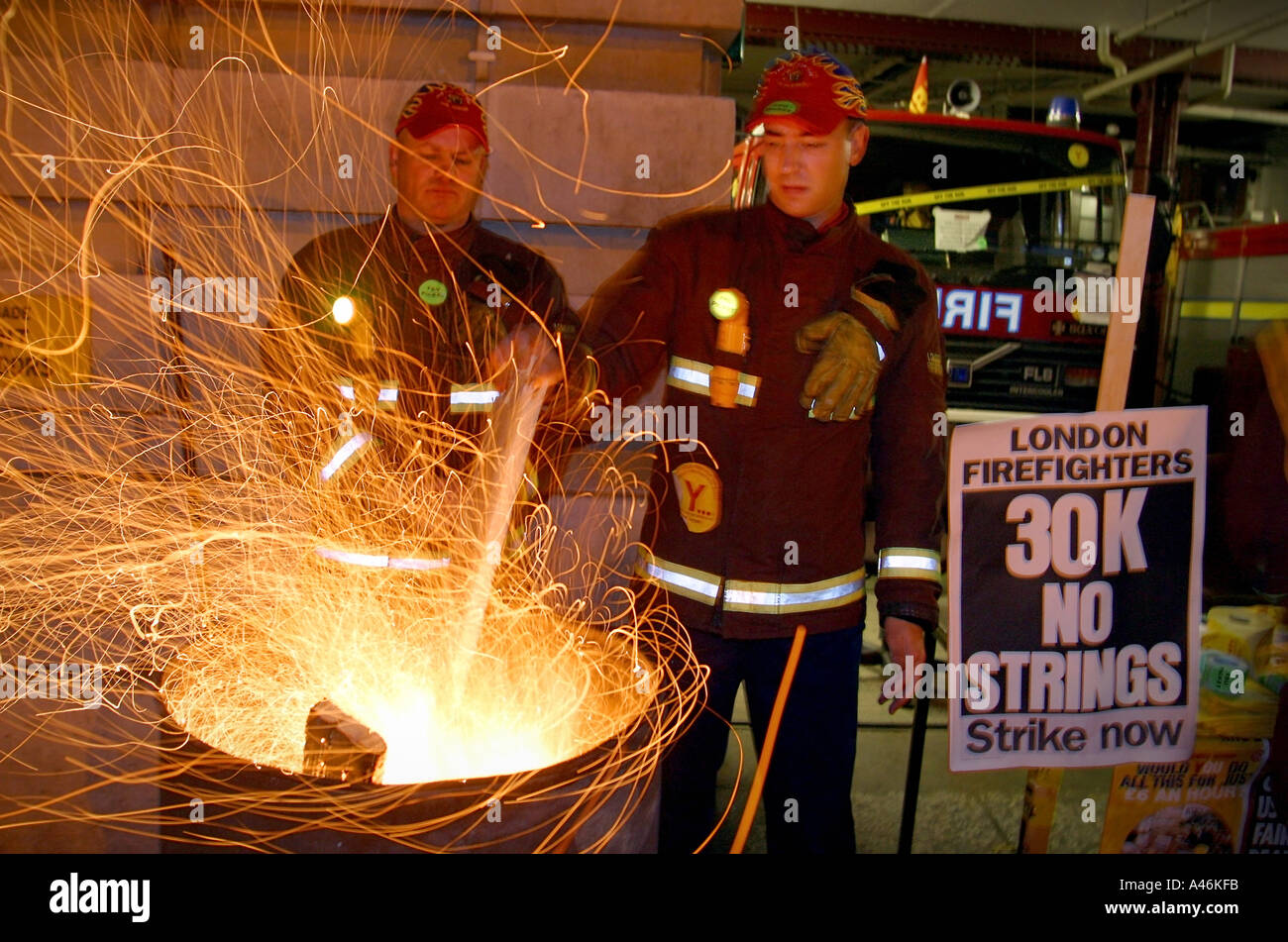 britsh firefighters strike striking firefighters add wood to a picket ...