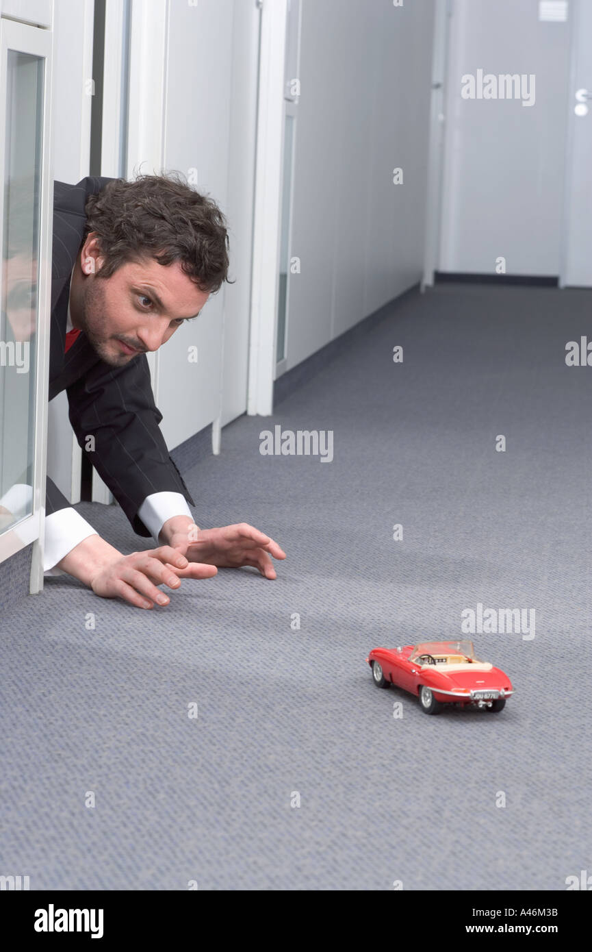 Mid adult businessman playing toy car hi-res stock photography and ...