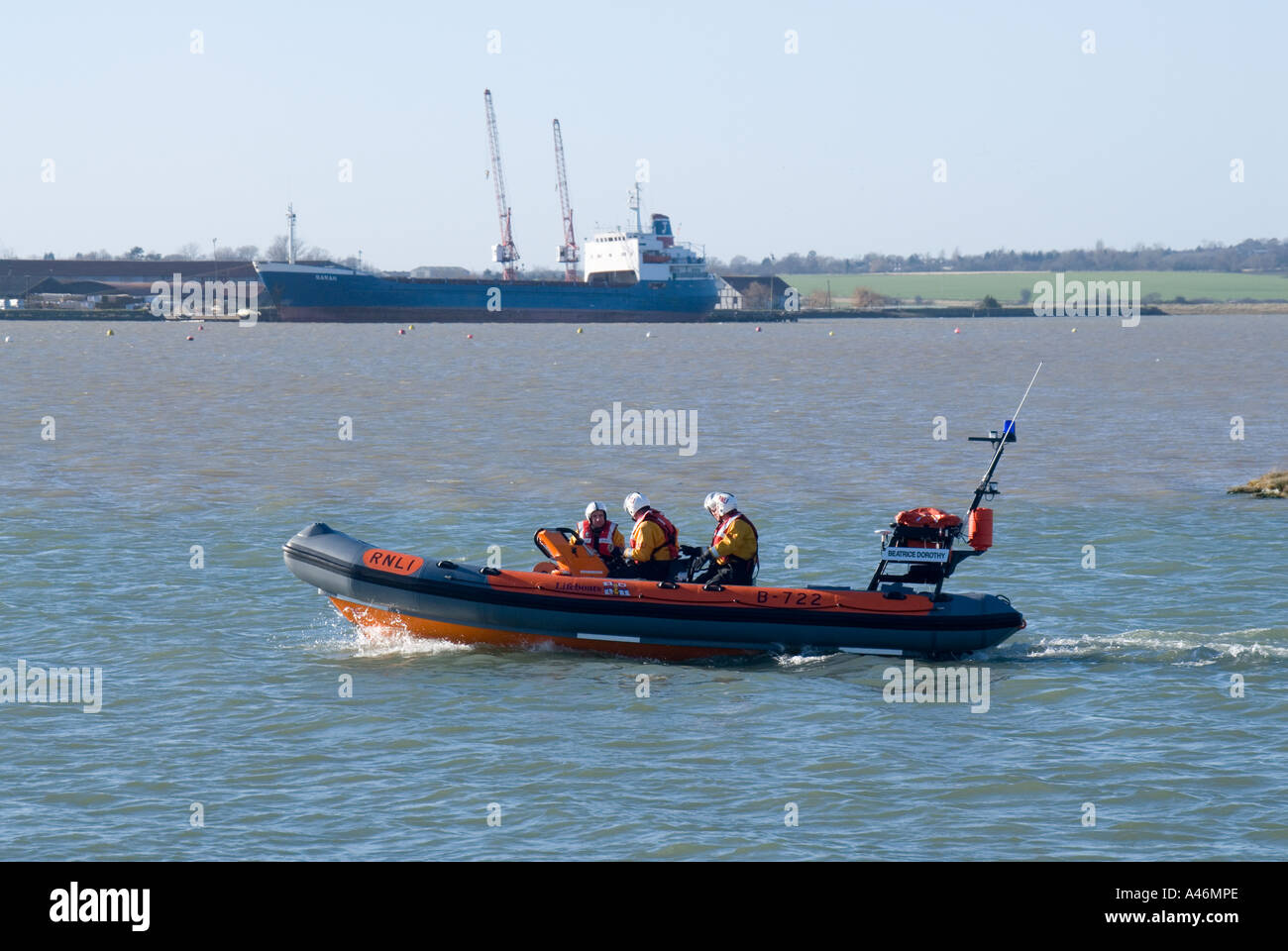 River Crouch RNLI inflatable lifeboat with crew and freighter beyond ...