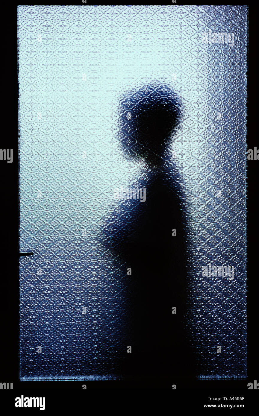 Silhouetted person through window Stock Photo - Alamy