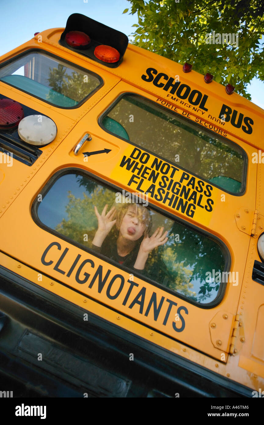 Child makes faces on school bus Stock Photo - Alamy