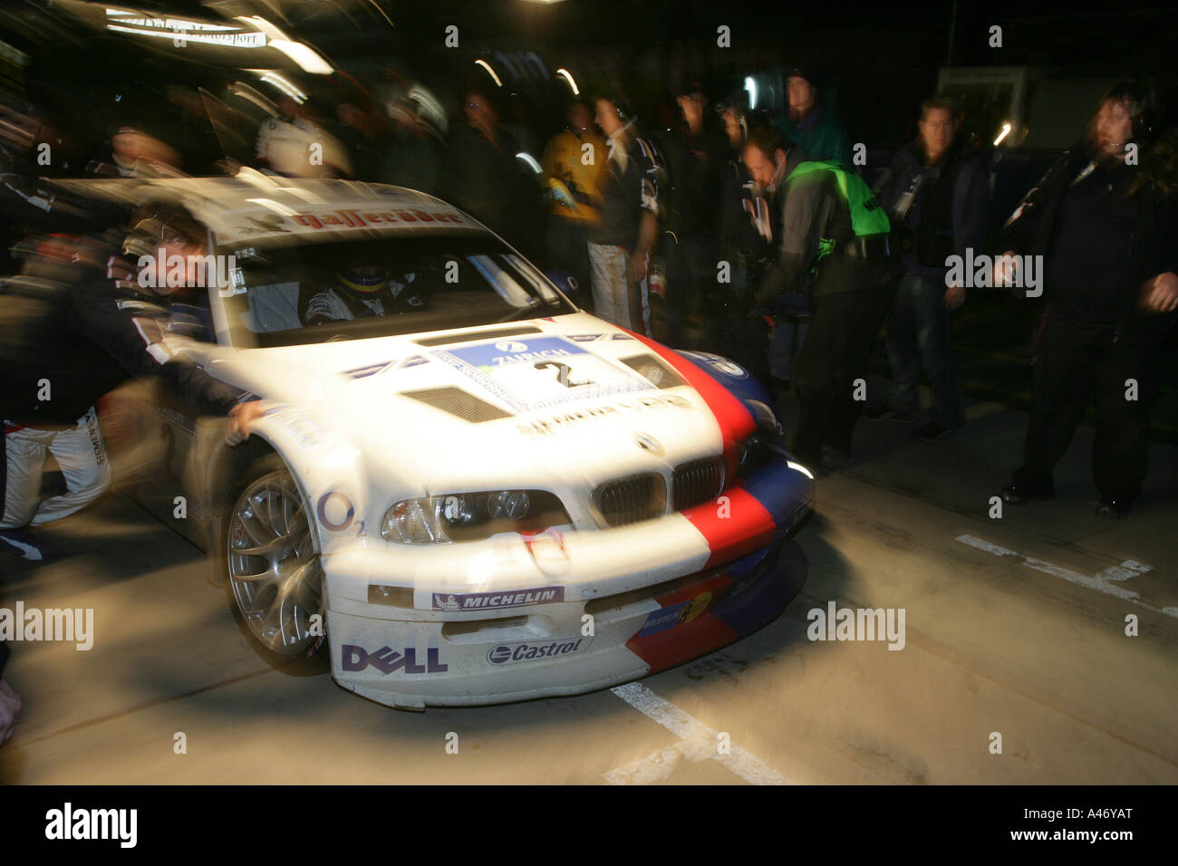 Mechanics push a BMW-Racecar out of the pit after a pit stop dring the ...